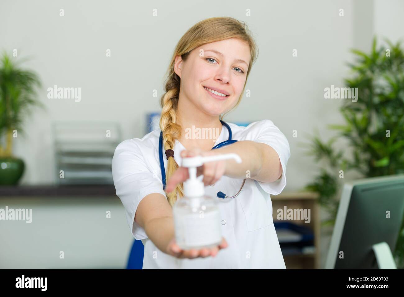 female nurse handing hand sanitizer Stock Photo - Alamy