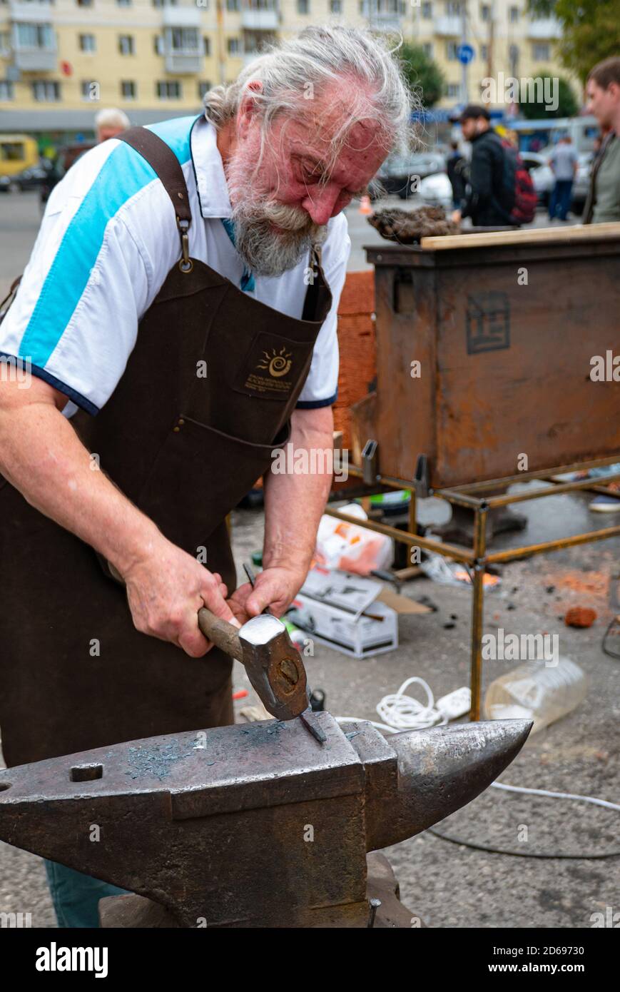 Ryazan, Russia - July 27, 2019: Old blacksmith with hammer on street ...