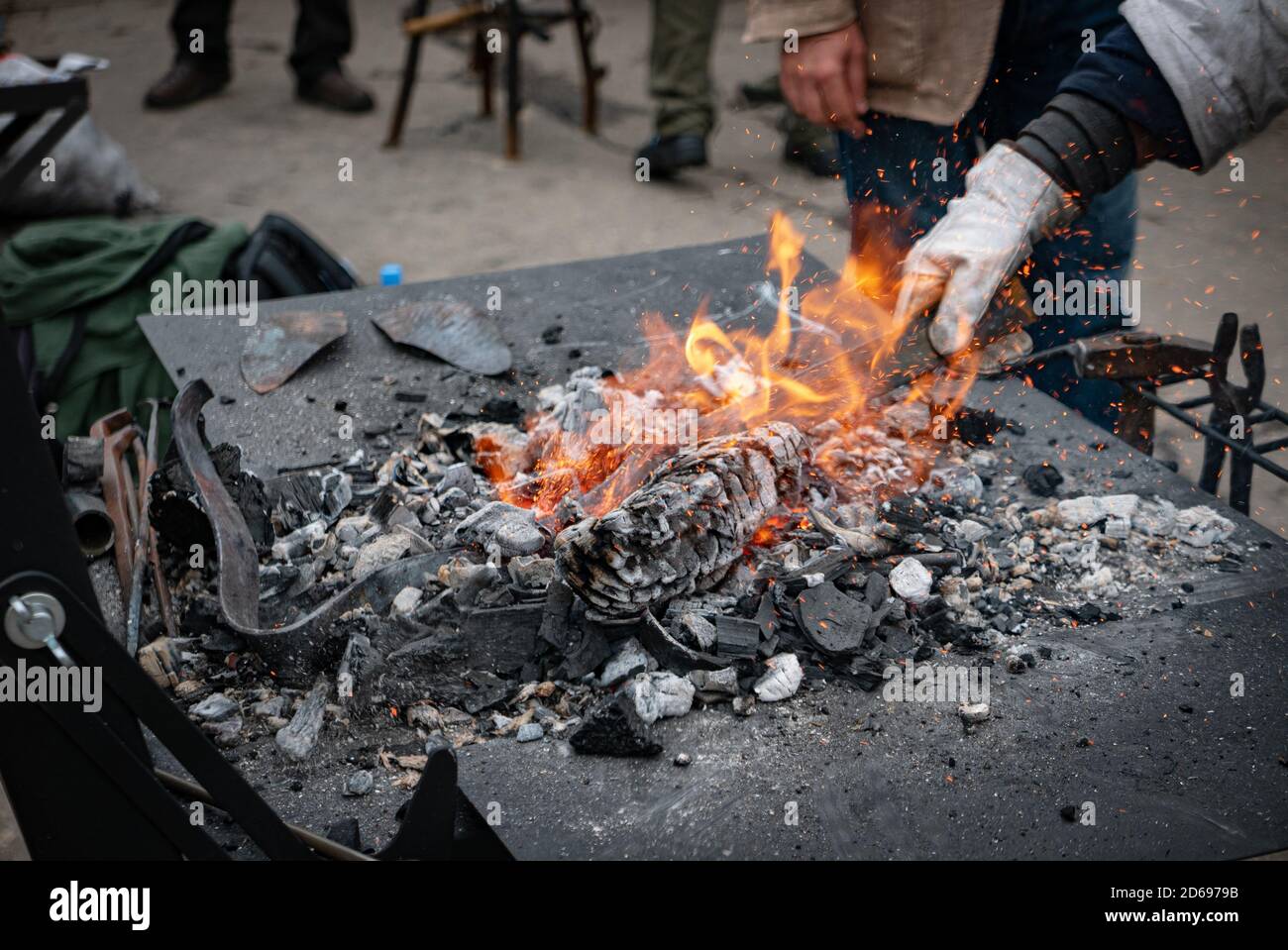 Blacksmith holds metal detail in a fire of forge fireplace Stock Photo ...