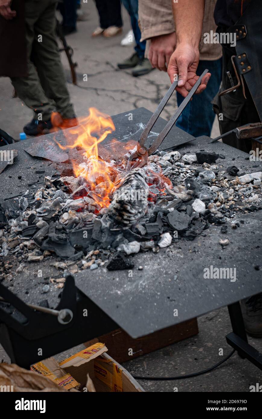 Blacksmith holds metal detail in a fire of forge fireplace Stock Photo ...