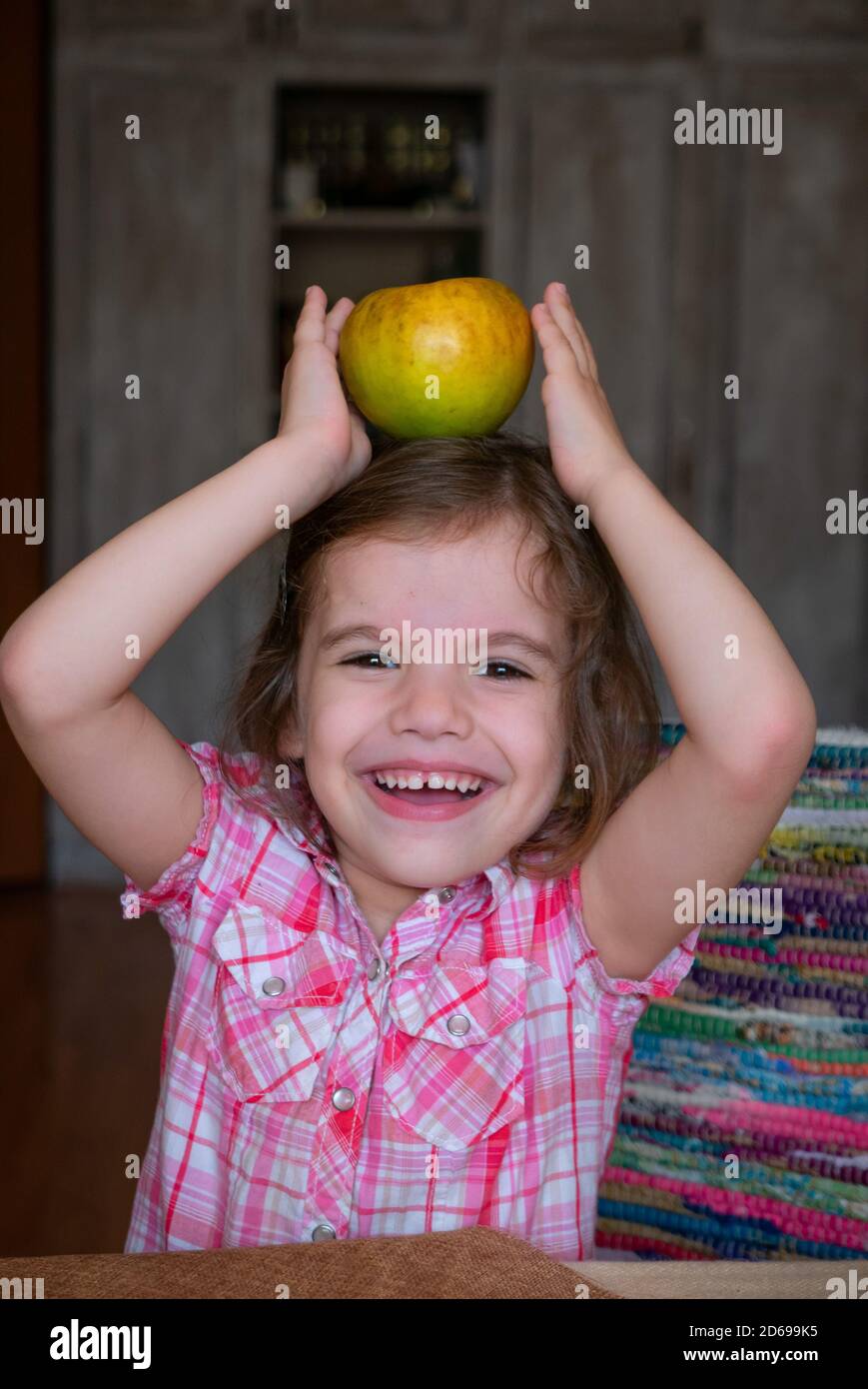Target concept - little kid girl with the apple on the head Stock Photo ...