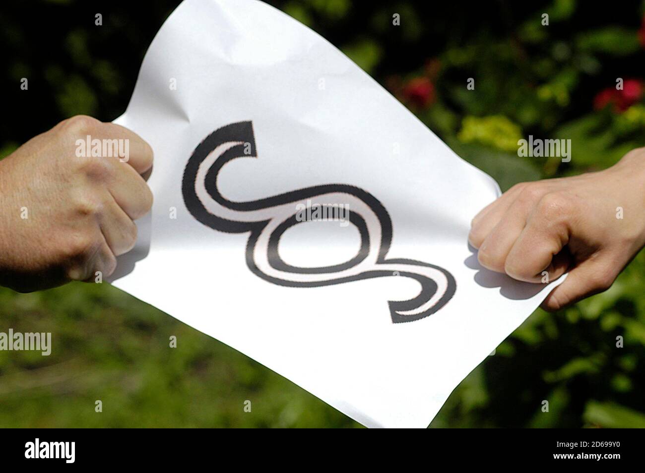 two people pulling on a paper with paragraph sign on it Stock Photo - Alamy