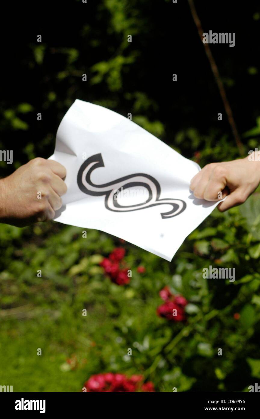 two people pulling on a paper with paragraph sign on it Stock Photo - Alamy