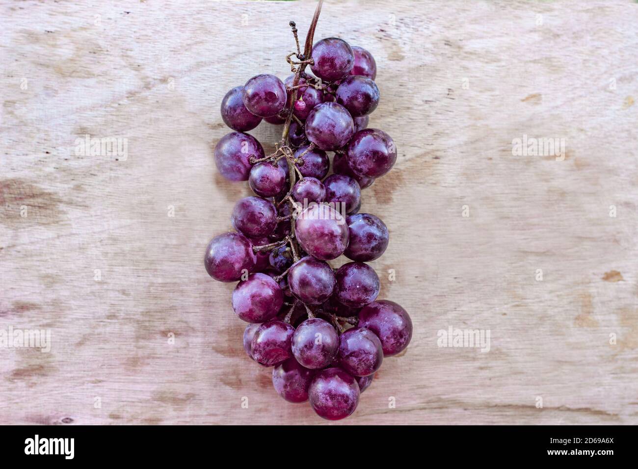 Fresh purple grapes on a rustic wooden surface, perfect for healthy ...