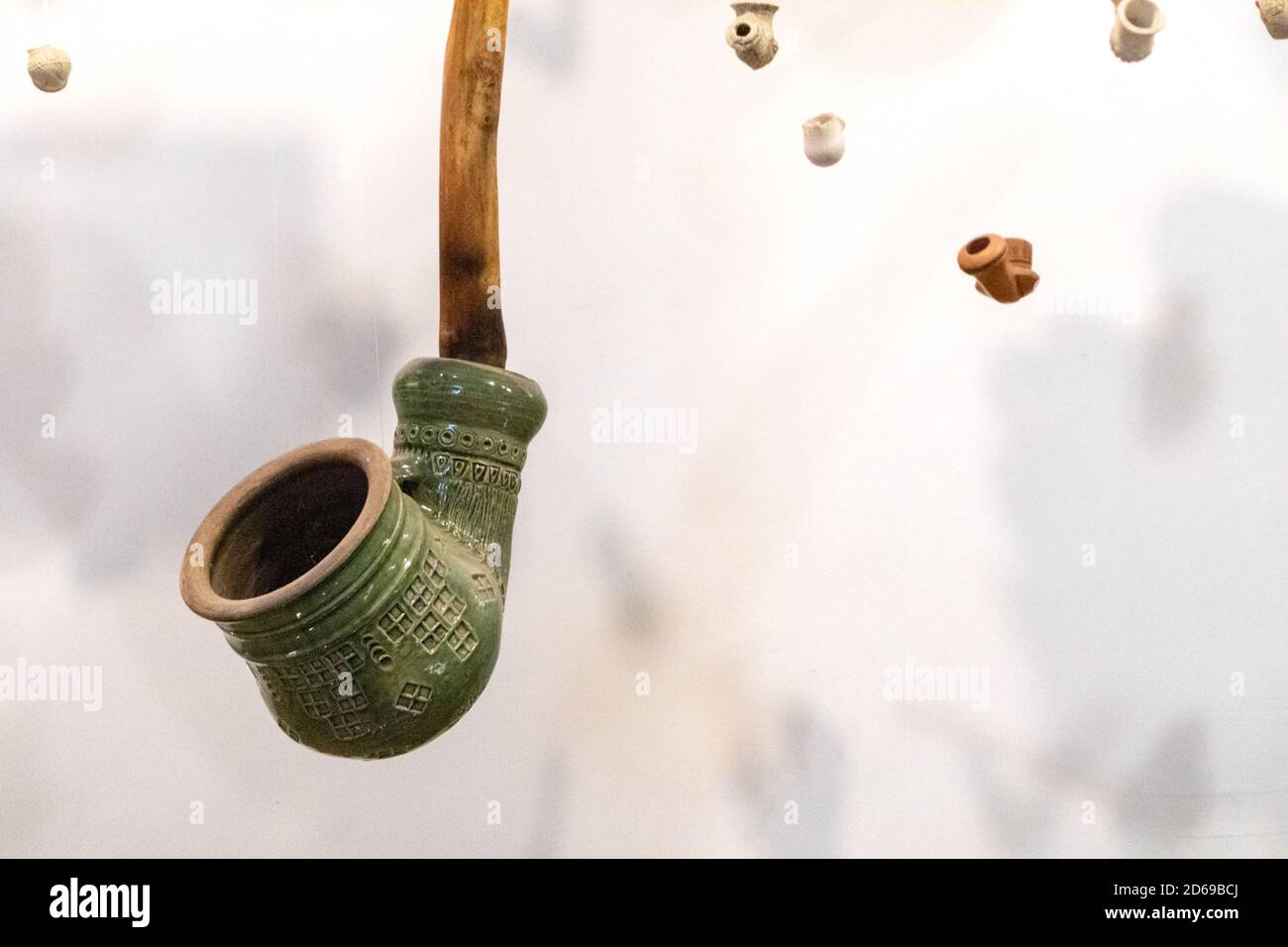 Vintage green ceramic tobacco smoking pipe installation on white ...