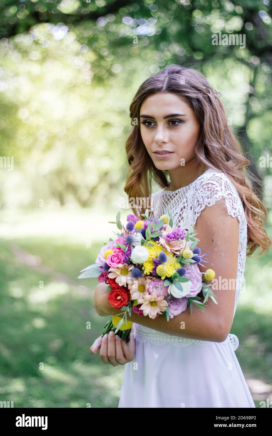 Wedding scene - bride with flower bouquet outdoor Stock Photo - Alamy