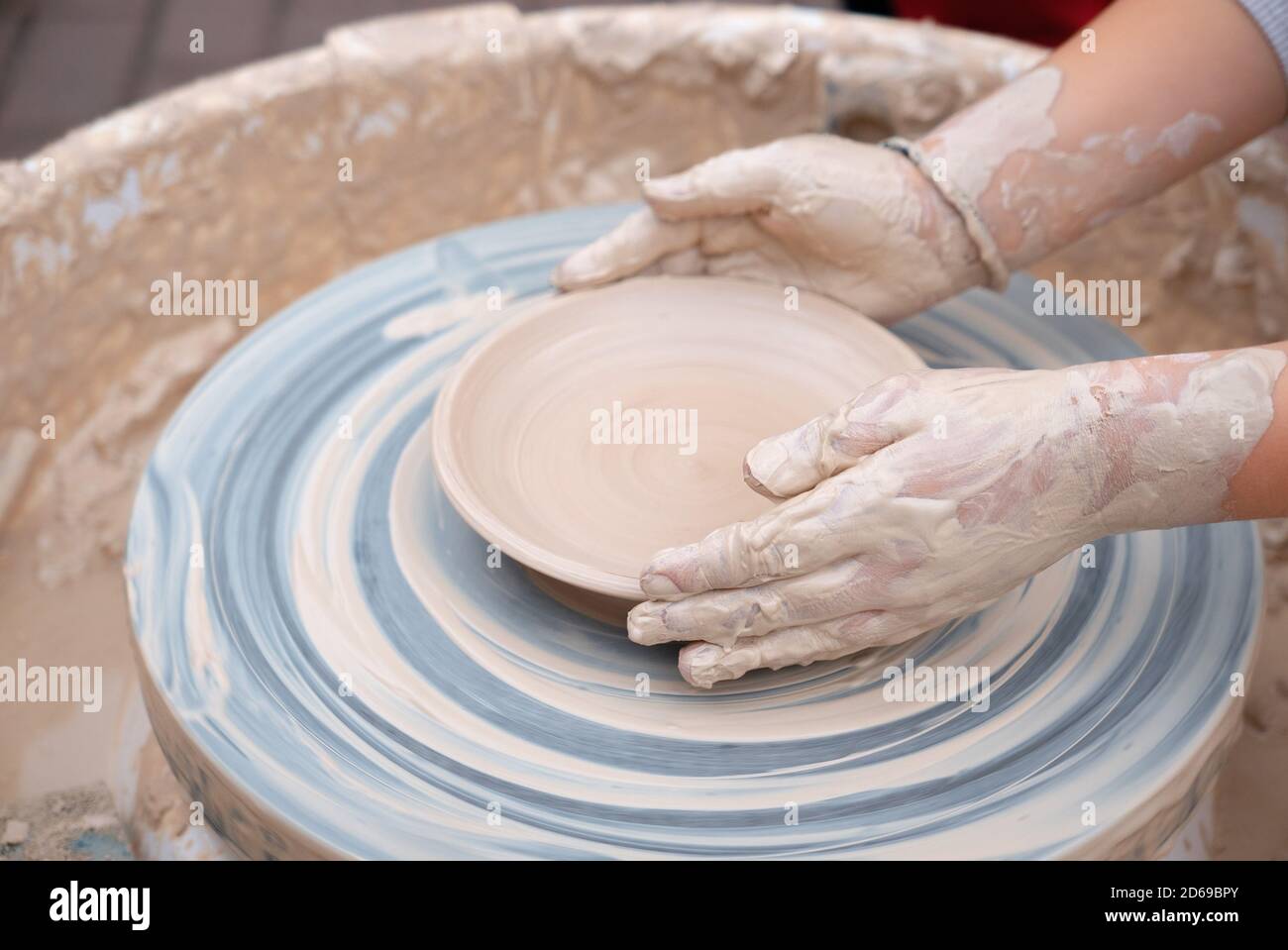 Hands forming clay on the pottery wheel Stock Photo - Alamy