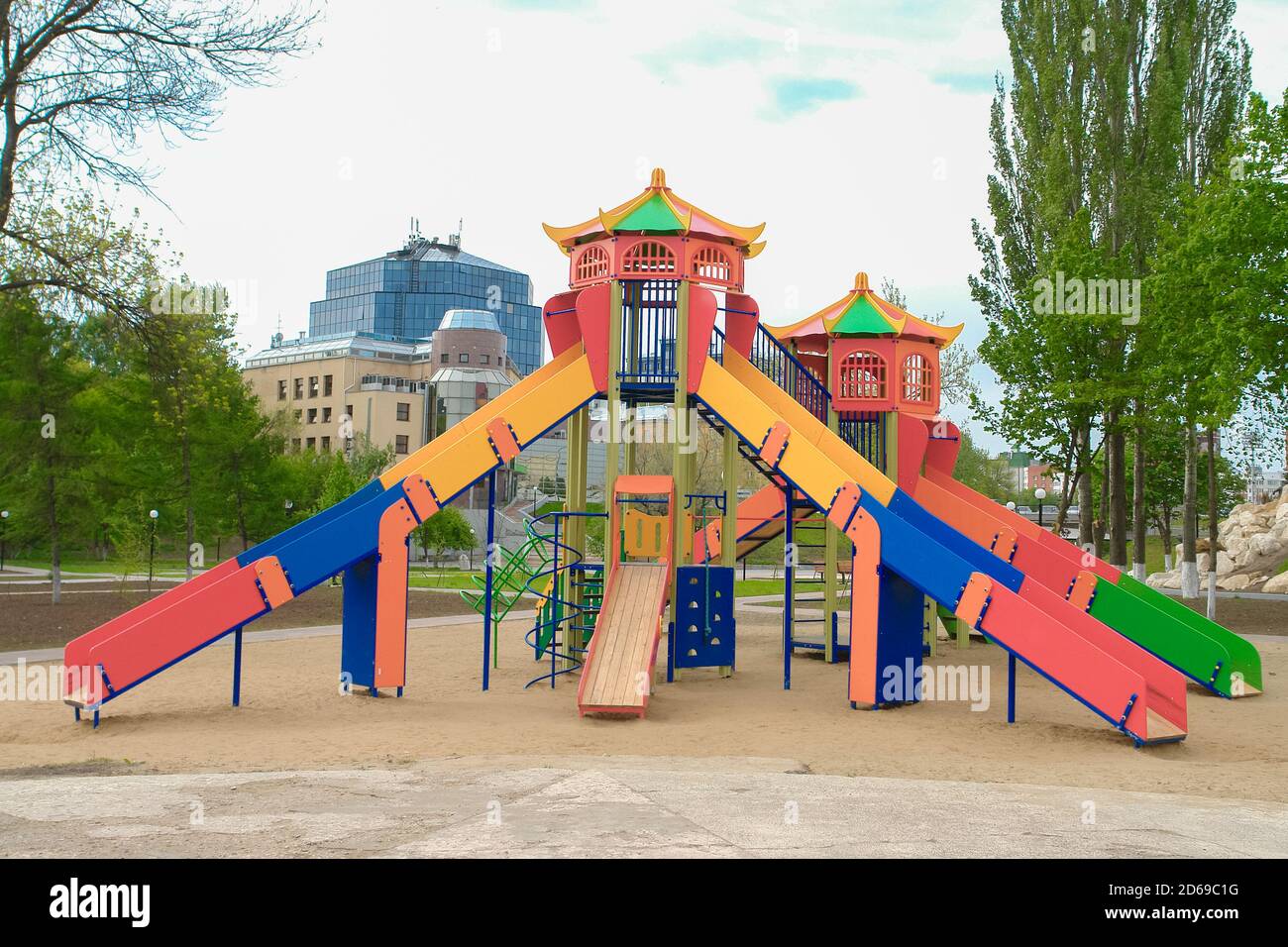 Colorful children playground on sand yard near beautiful buildings ...