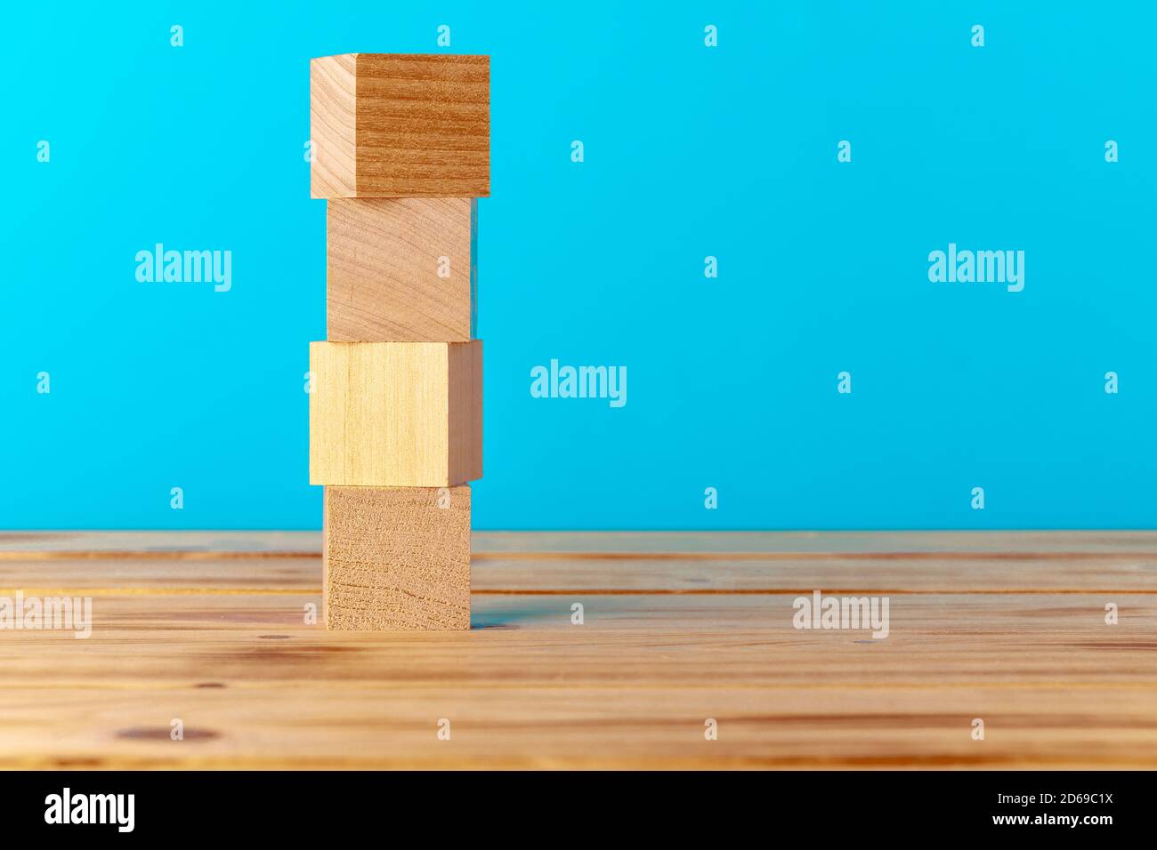 Stacked wooden blocks on wooden desk against blue background Stock ...