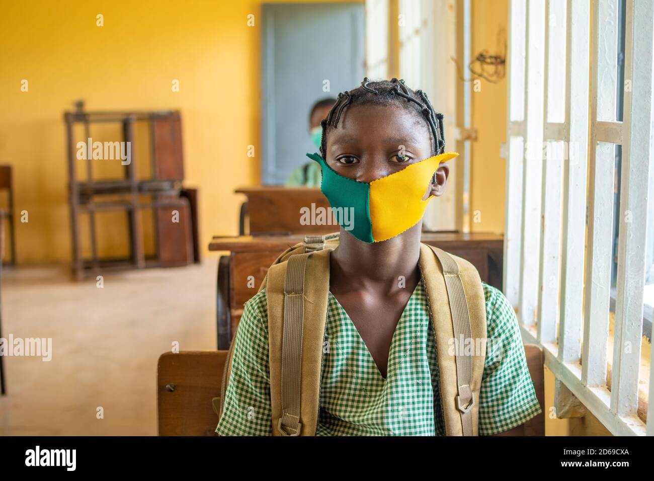 primary school pupil's sitting in class, wearing face masks, and ...