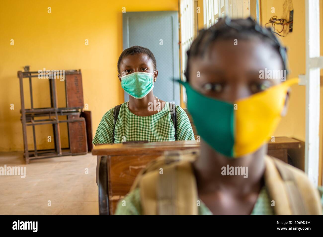 african primary school pupil's sitting in class, wearing face masks ...