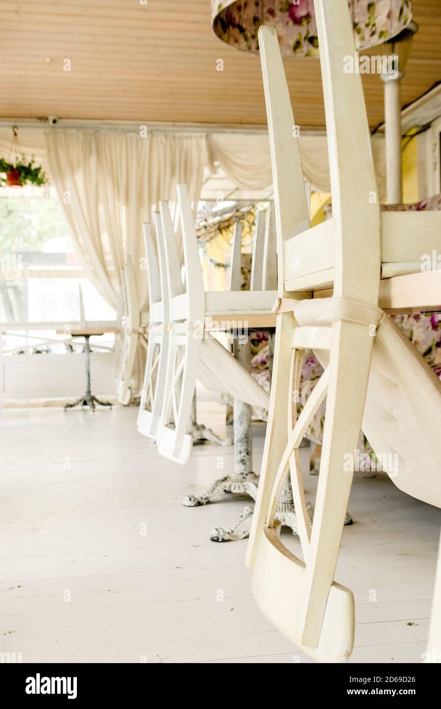 White chairs on tables upside down on street cafe summer terrace Stock ...
