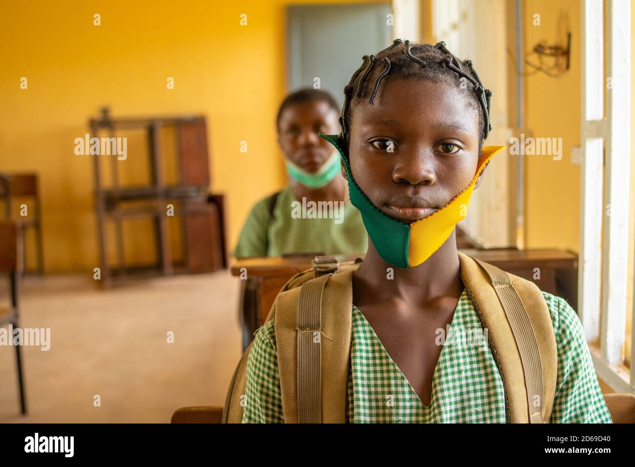 primary school pupil's sitting in class, wearing face masks, and ...