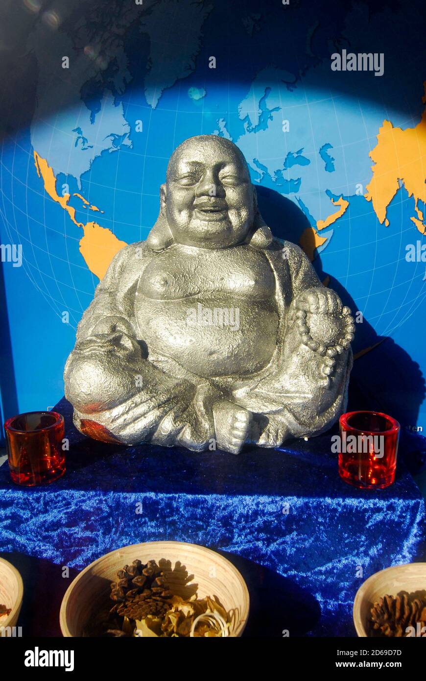 statue of laughing Buddha in front of blue world map Stock Photo - Alamy