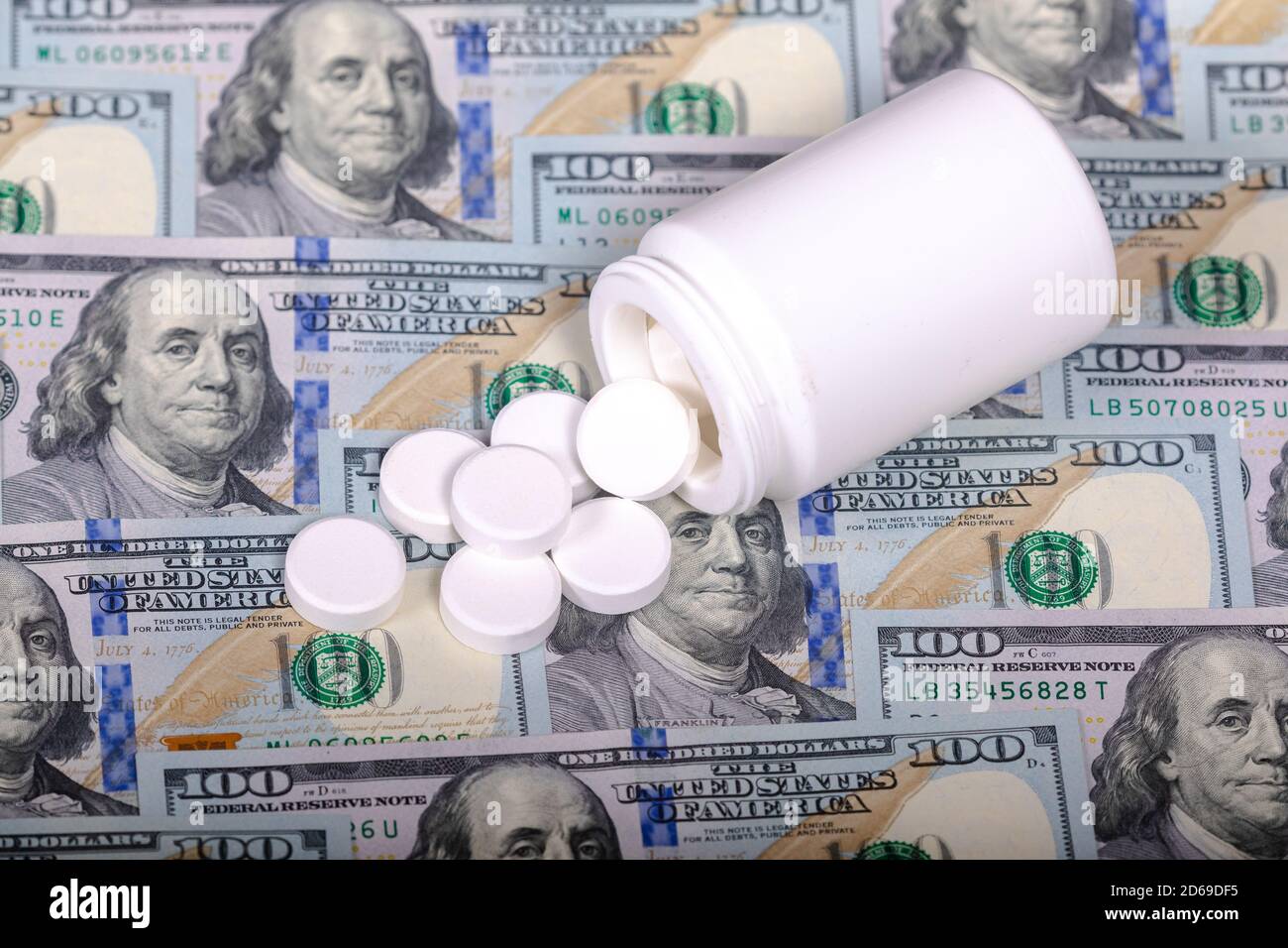 White pills lies on one hundred dollar bill, close-up. Healthcare ...