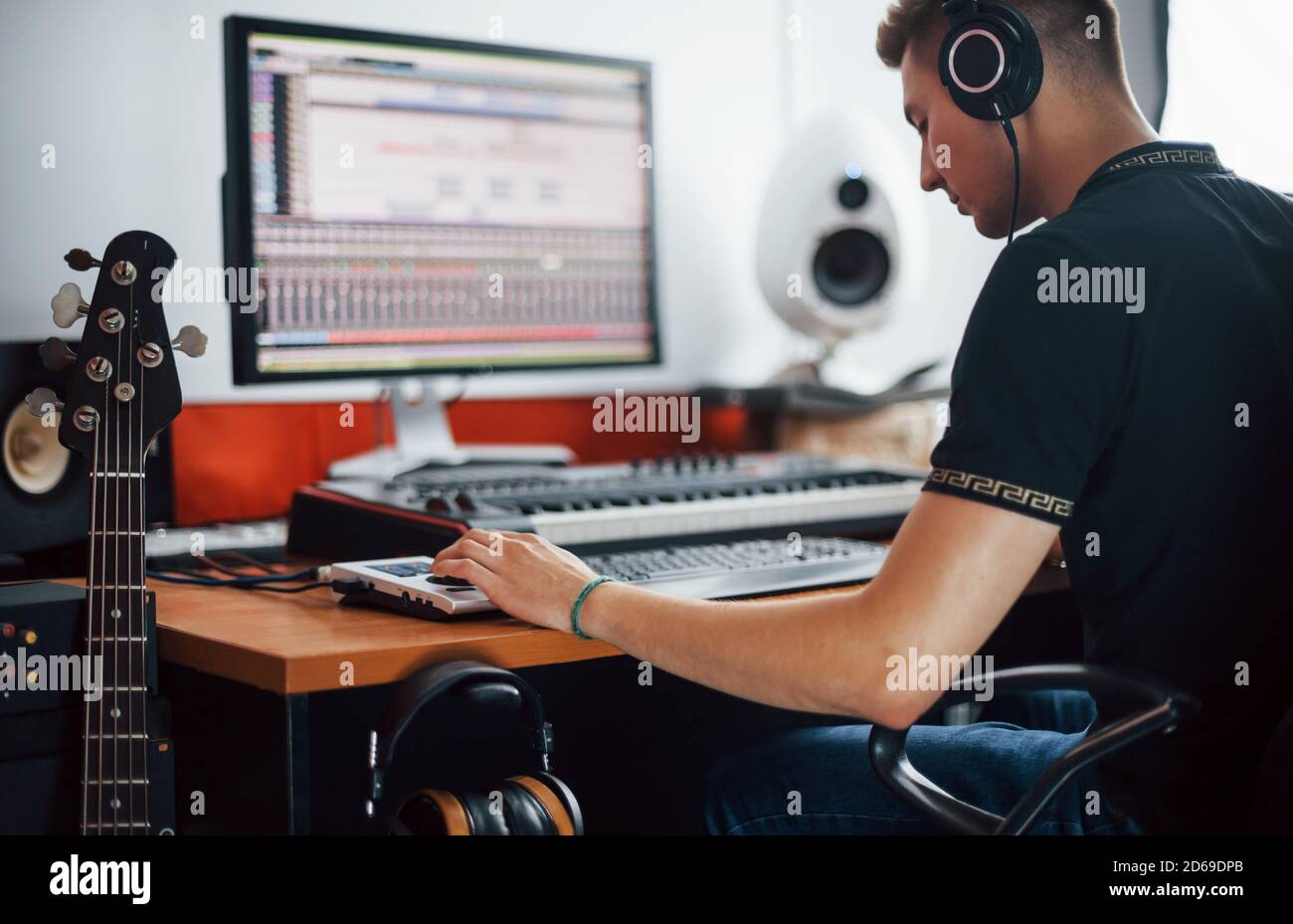 Sound engineer in headphones working and mixing music indoors in the ...
