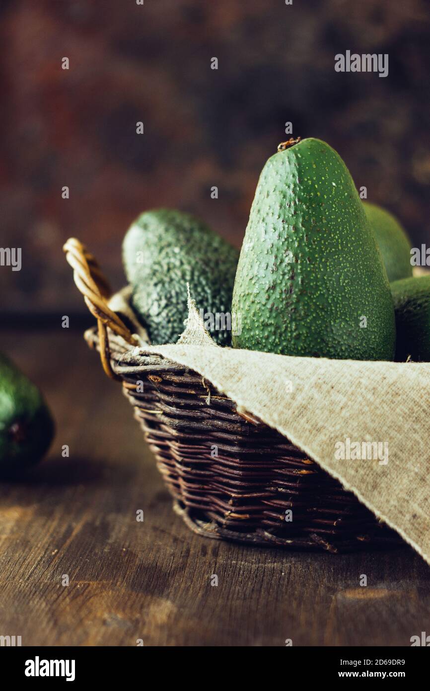 Avocado fruits in basket on wooden rustic background Stock Photo - Alamy
