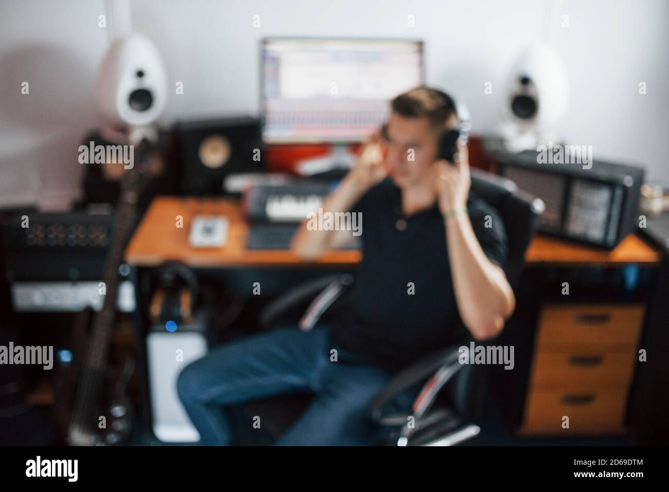 Sound engineer in headphones working and mixing music indoors in the ...