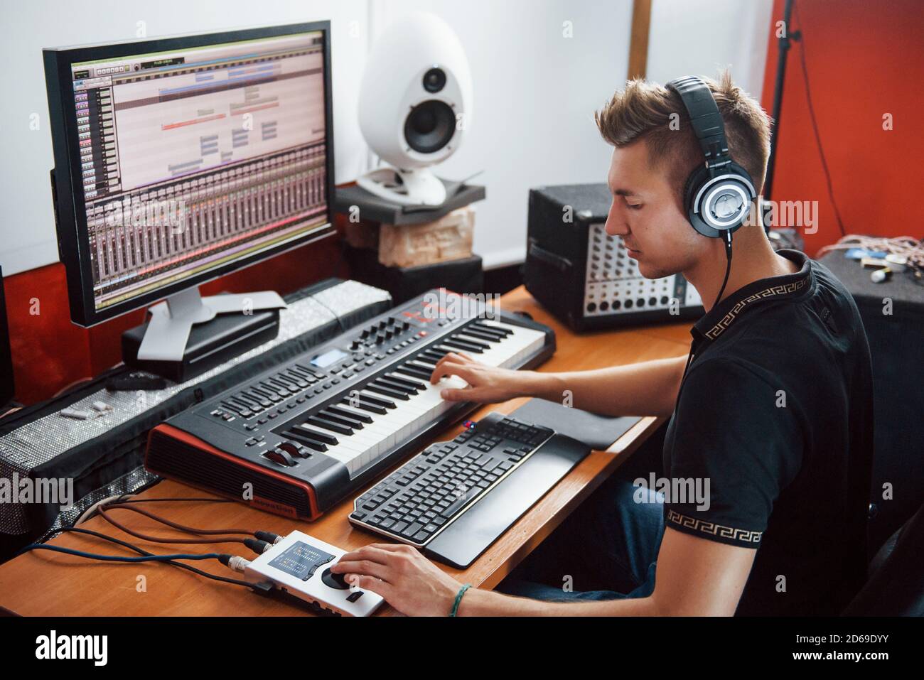 Sound engineer in headphones working and mixing music indoors in the ...