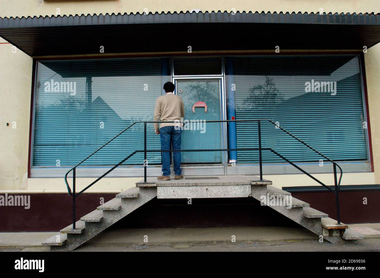 man standing in front of the door of a vacant business premises Stock ...