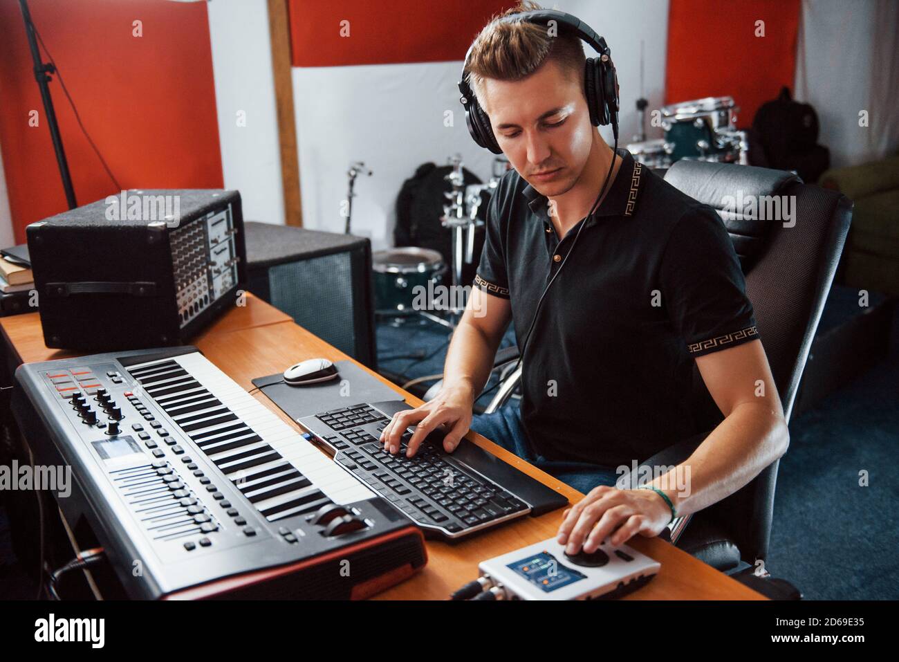 Sound engineer in headphones working and mixing music indoors in the ...