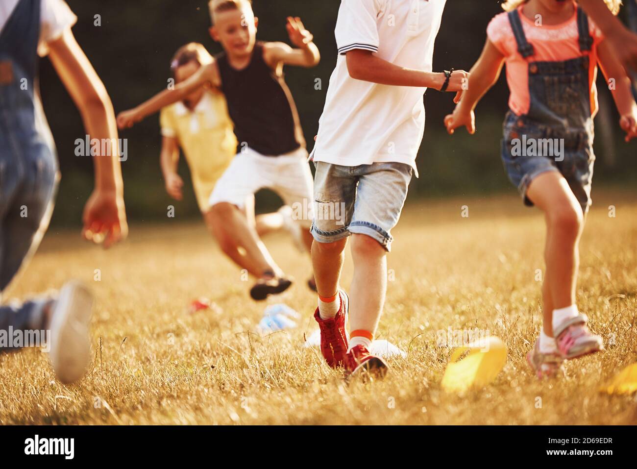 Through obstacles. Kids running in the field at sunny day. Conception ...