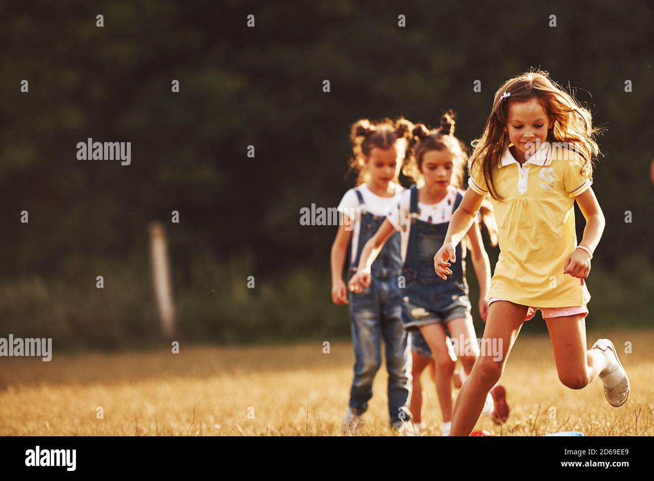 Through obstacles. Kids running in the field at sunny day. Conception ...