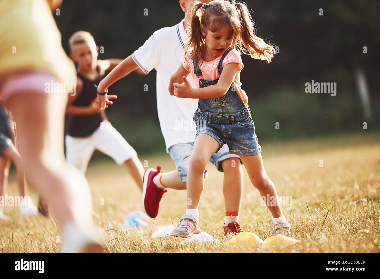 Through obstacles. Kids running in the field at sunny day. Conception ...