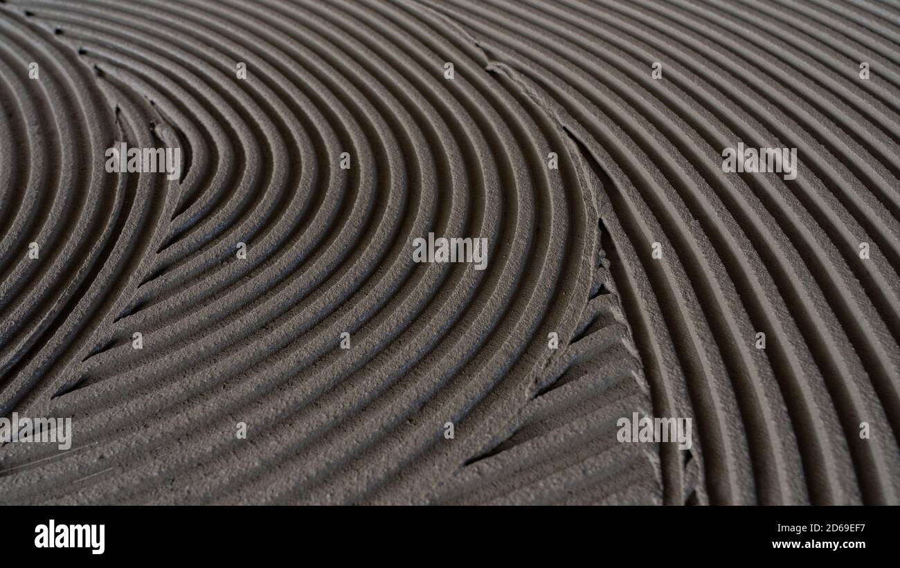 cementitious adhesive applied to the floor ready to receive the ceramic ...