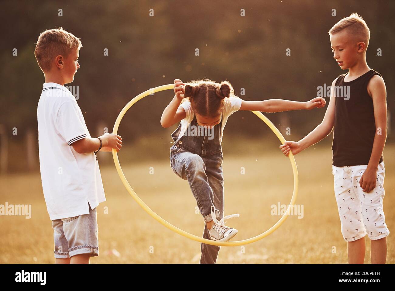 Jumping through the circle fitness tool. Kids having fun in the field ...