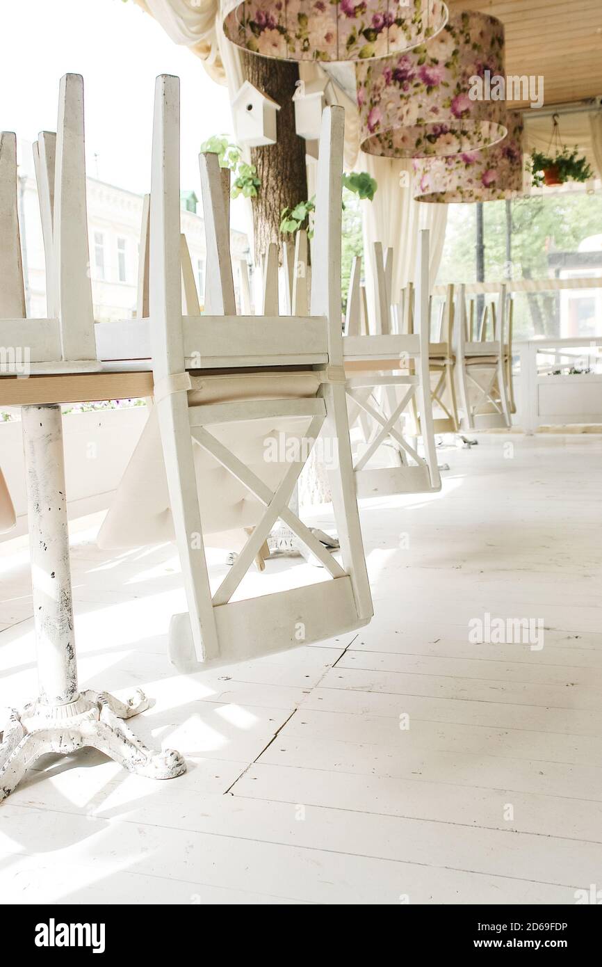 White chairs on tables upside down on street cafe summer terrace Stock ...