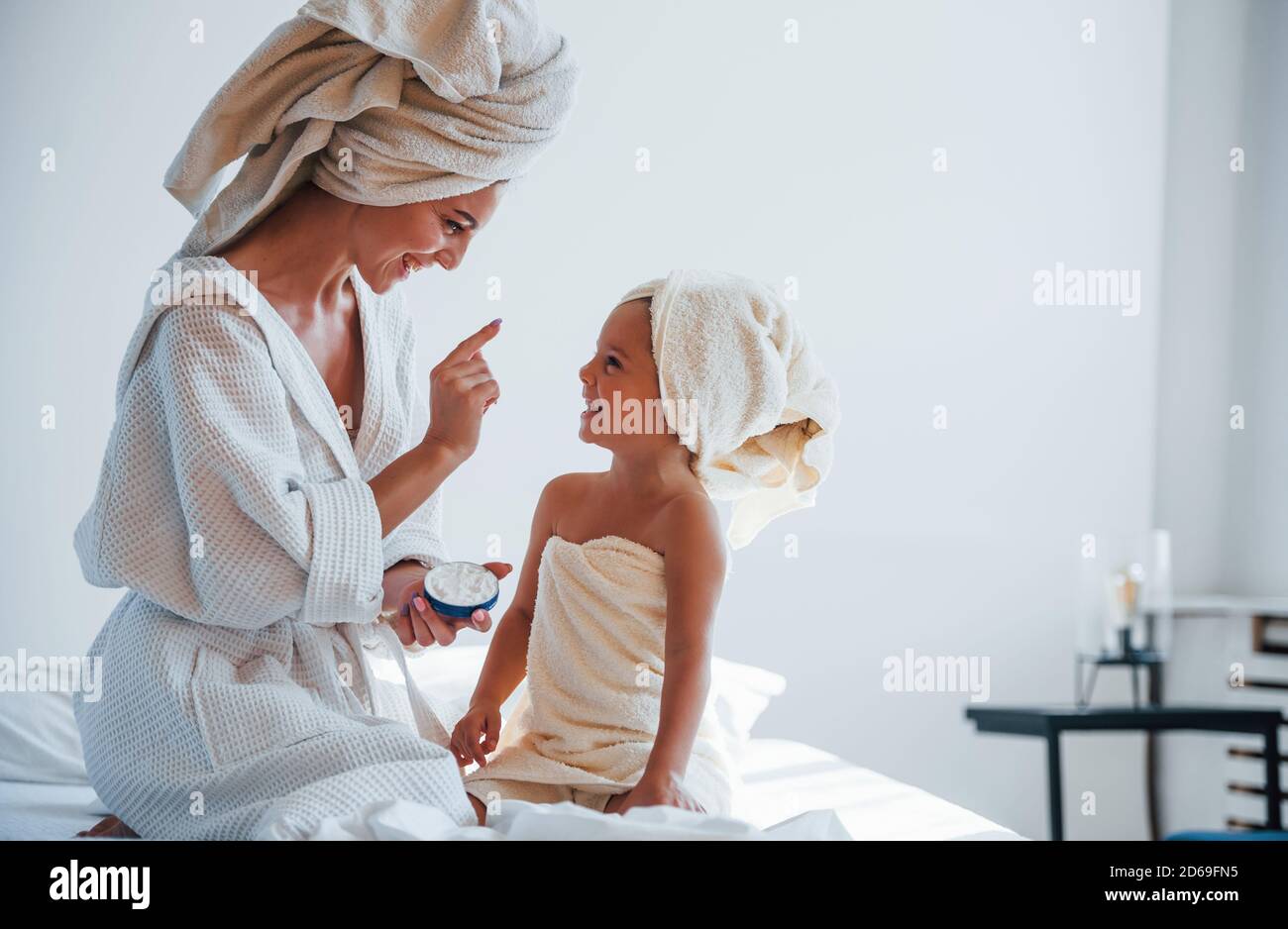 Using cream to clear skin. Young mother with her daugher have beauty ...