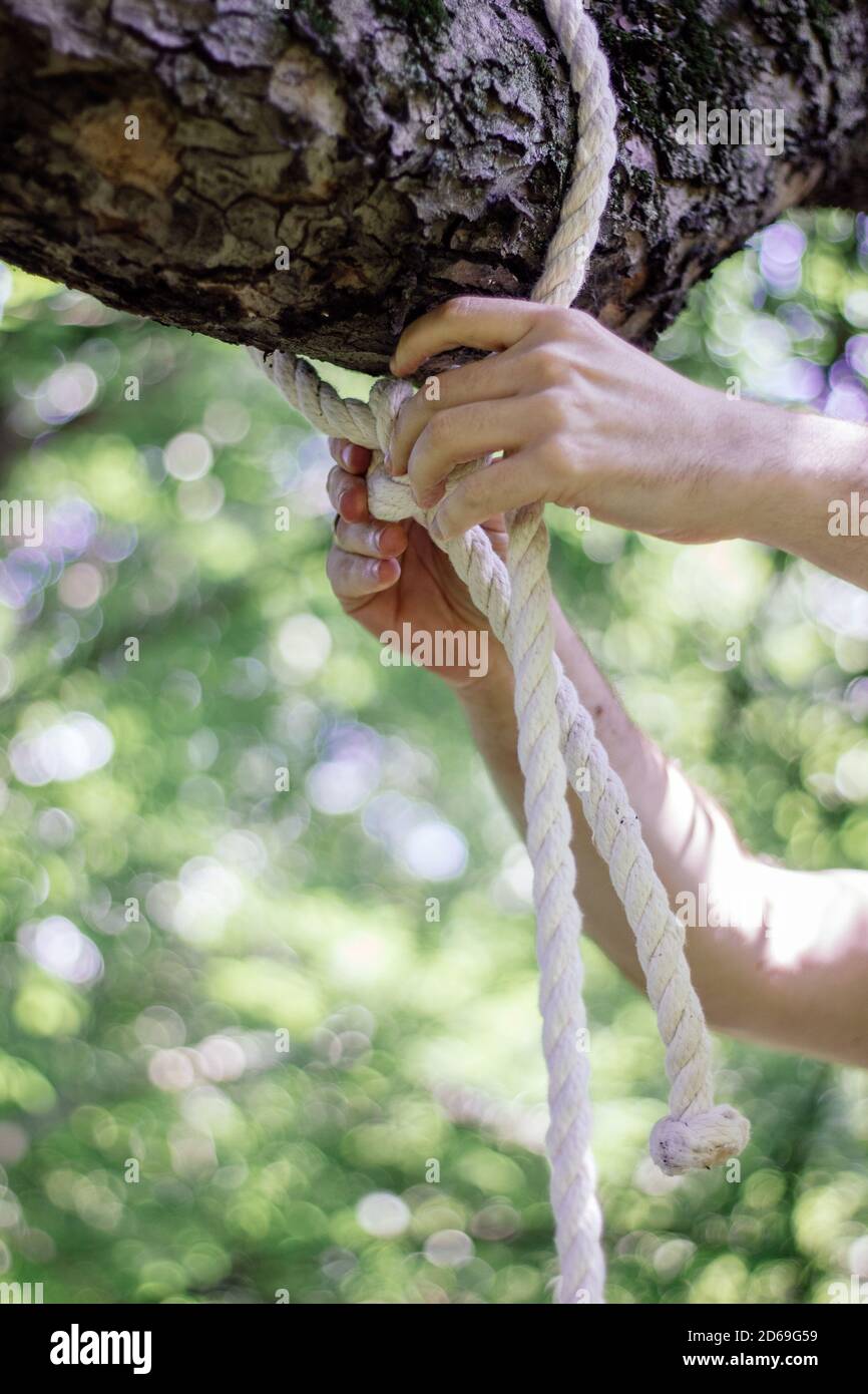 human hands tie a rop in knot at green forest Stock Photo - Alamy