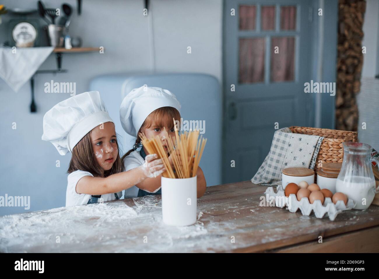 Having fun with spaghetti. Family kids in white chef uniform preparing ...