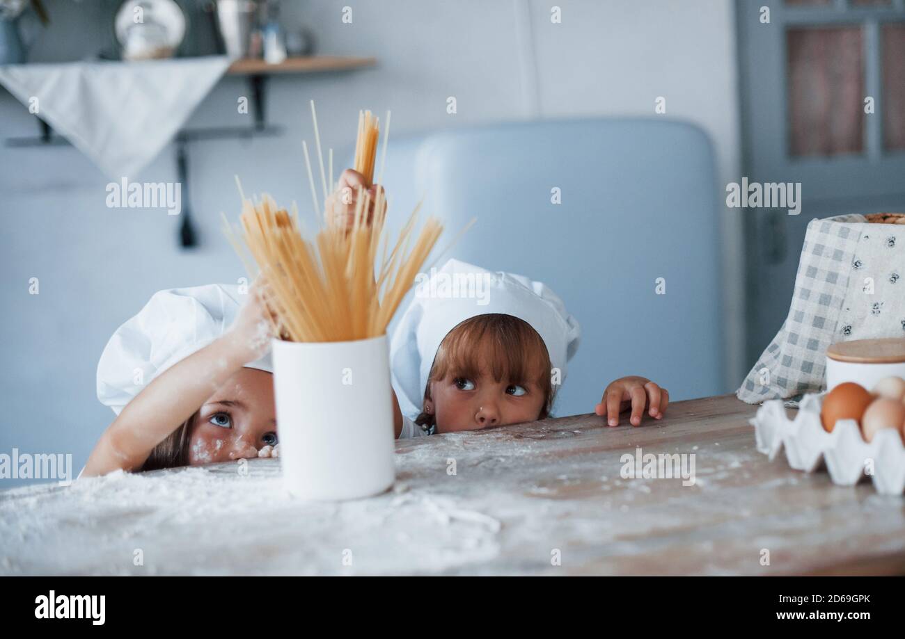 Having fun with spaghetti. Family kids in white chef uniform preparing ...