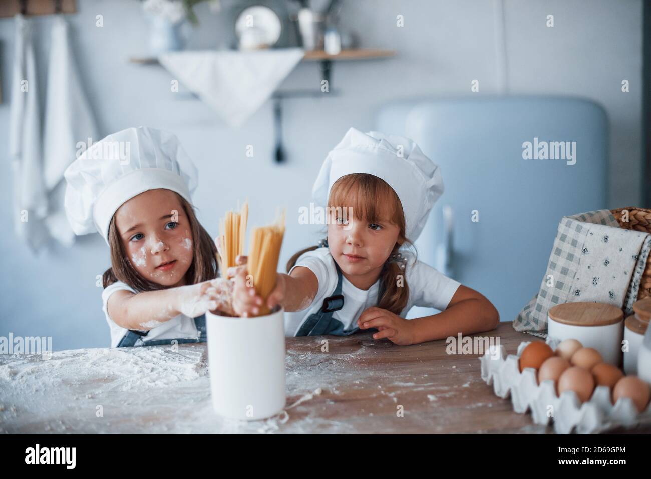 Having fun with spaghetti. Family kids in white chef uniform preparing ...