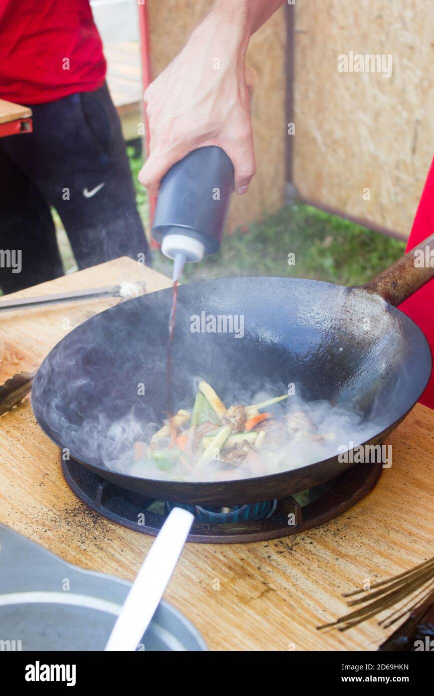 Traditional chinese food - wok cooking on open fire Stock Photo - Alamy
