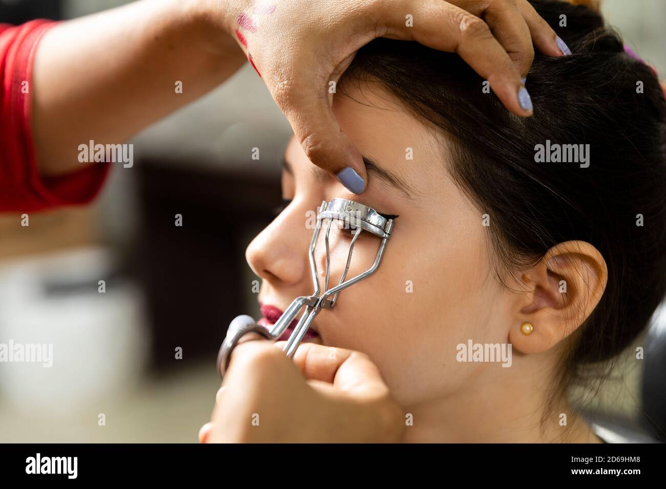 An attractive young Indian woman gets her eyes stylised, beautician ...
