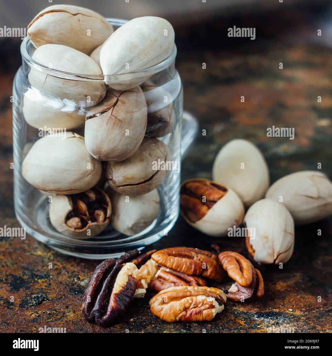 Pecan nuts inside glass jar on rustic surface Stock Photo - Alamy