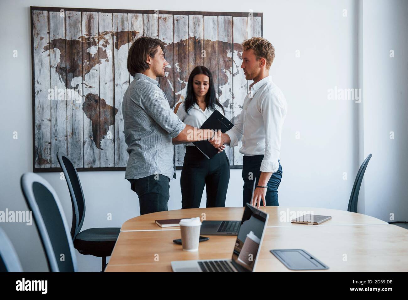 Successful deal, makes handshake. Young business people in formal ...