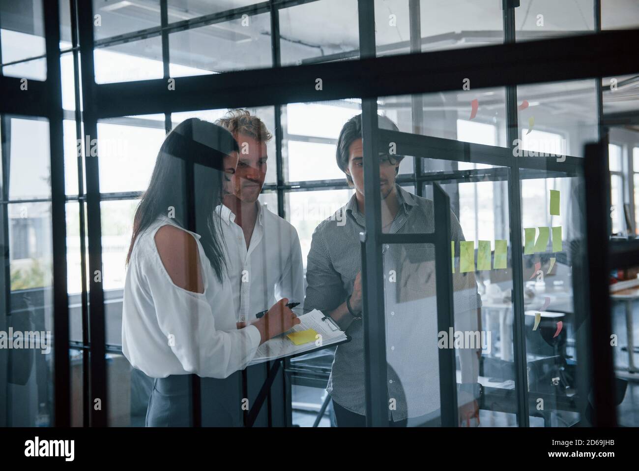 Yellow stickers is on the glass. Young business people in formal ...