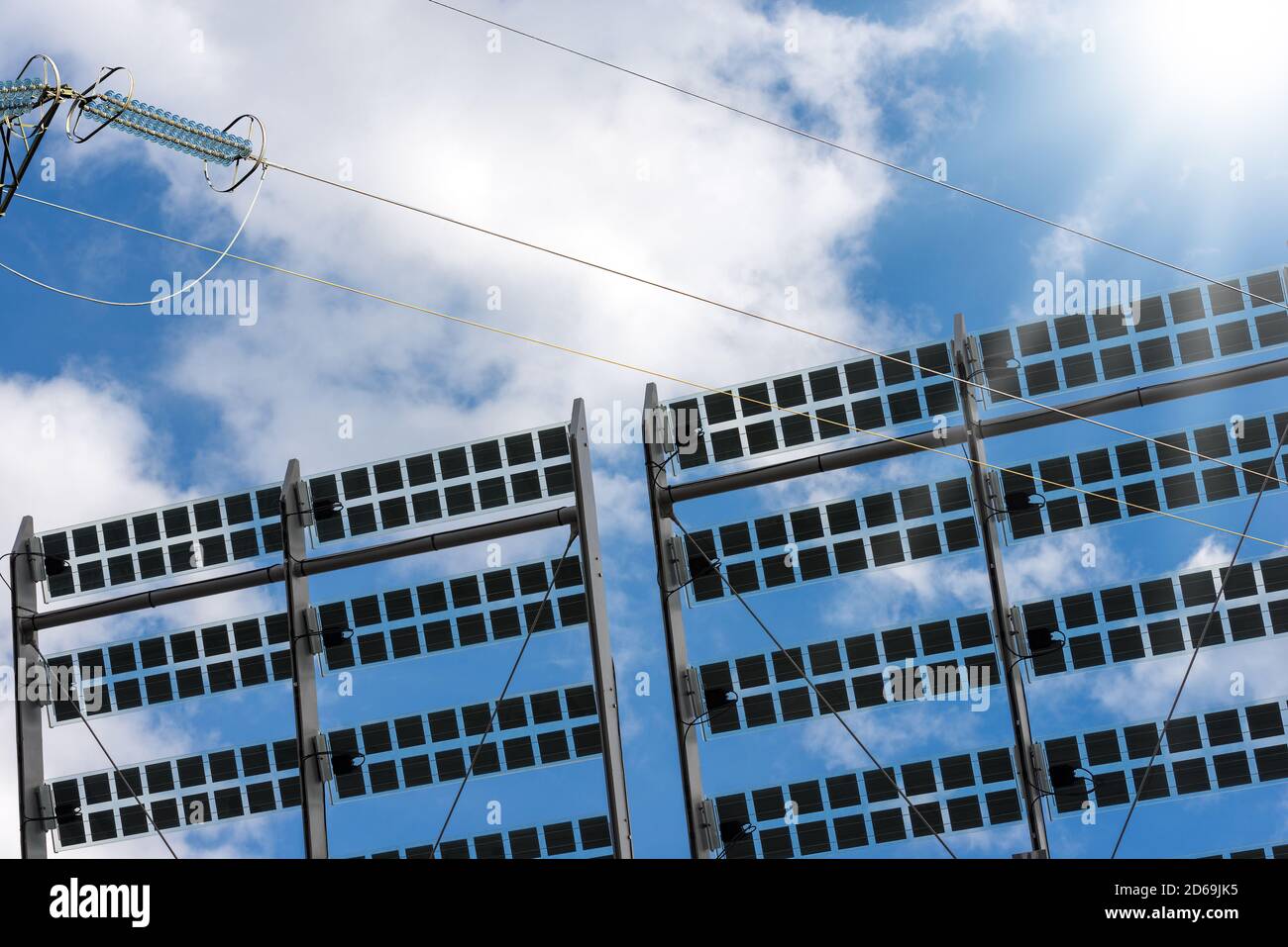 Solar panels and a power line on a blue sky with clouds and sun rays ...