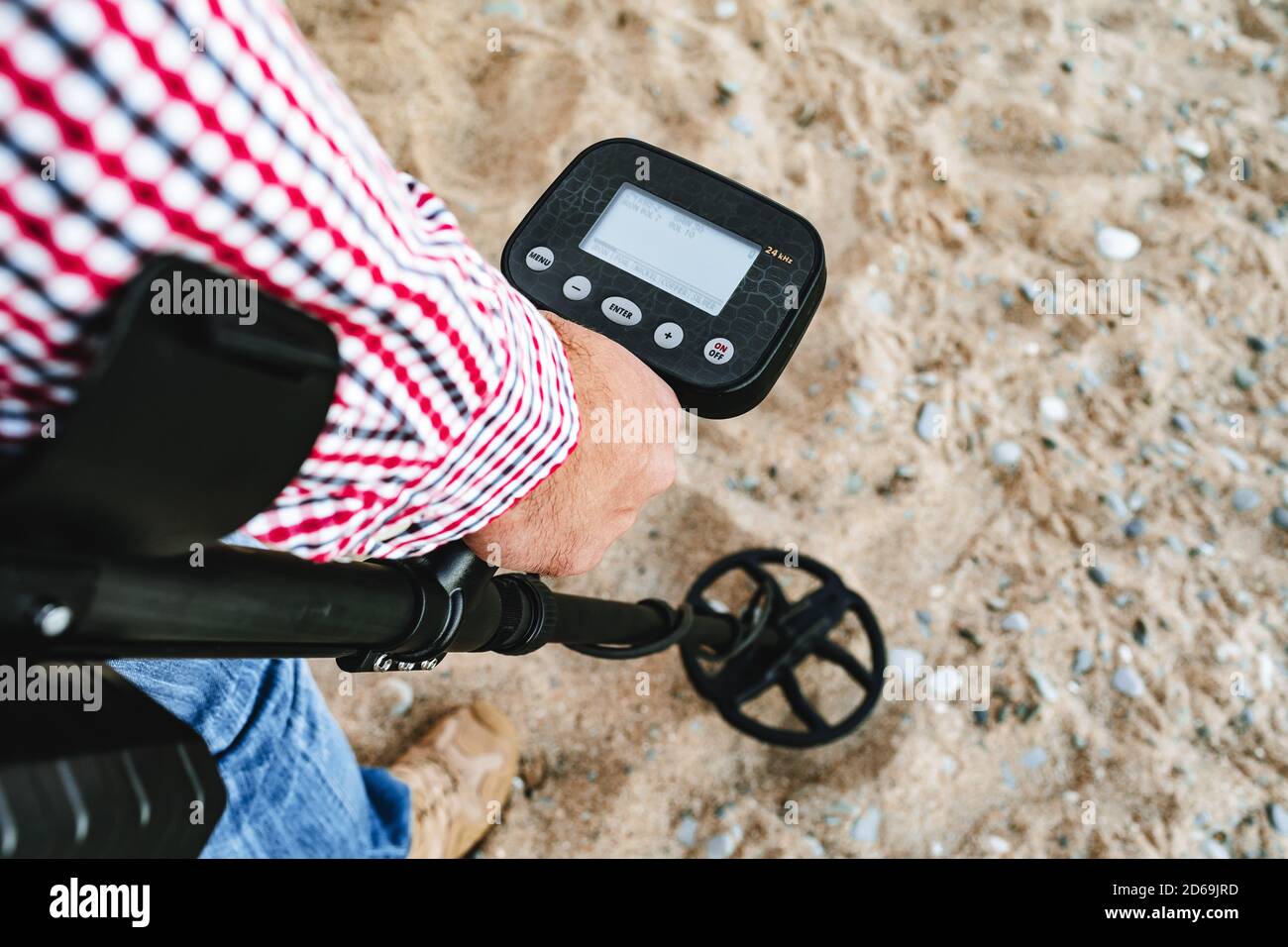 Male hand holding metal detector device above the ground Stock Photo ...