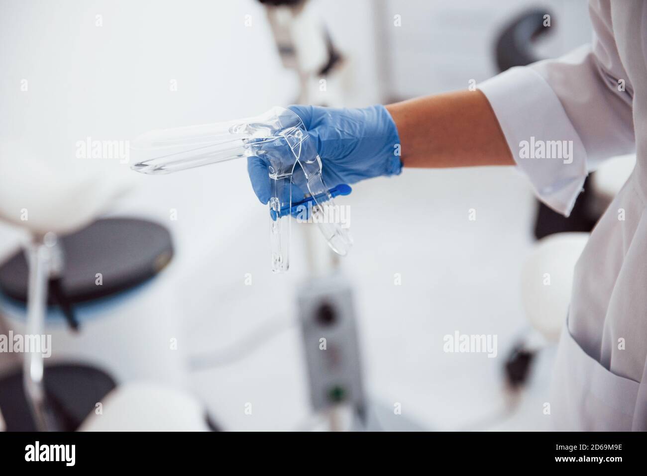 Close up view of female doctor hands that holds speculum instrument ...