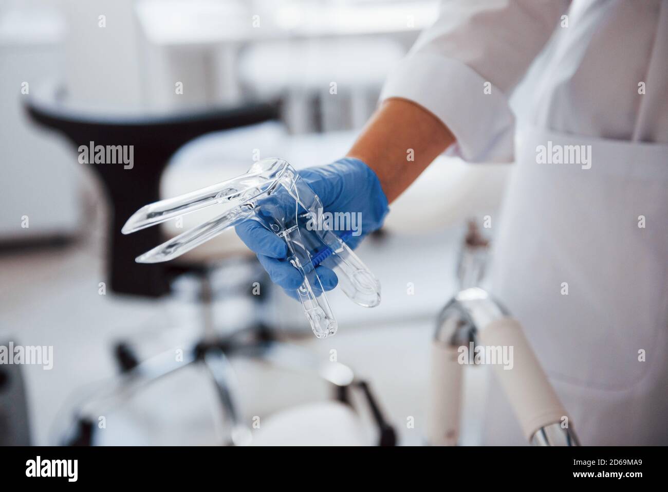 Close up view of female doctor hands that holds speculum instrument ...