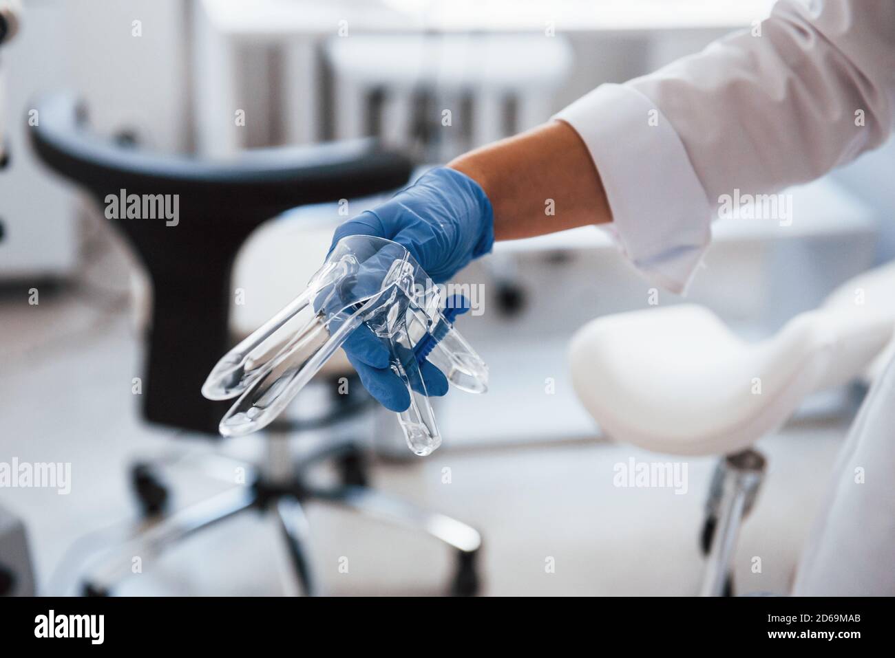 Close up view of female doctor hands that holds speculum instrument ...