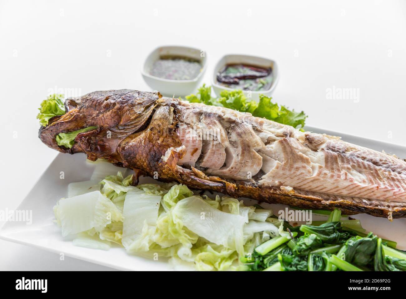 Grilled fish with vegetable and sauce on white background Stock Photo ...