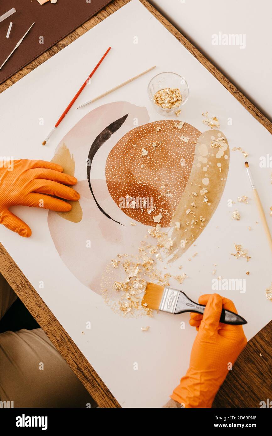 Artist with orange gloves and a paintbrush doing a unique artwork Stock ...