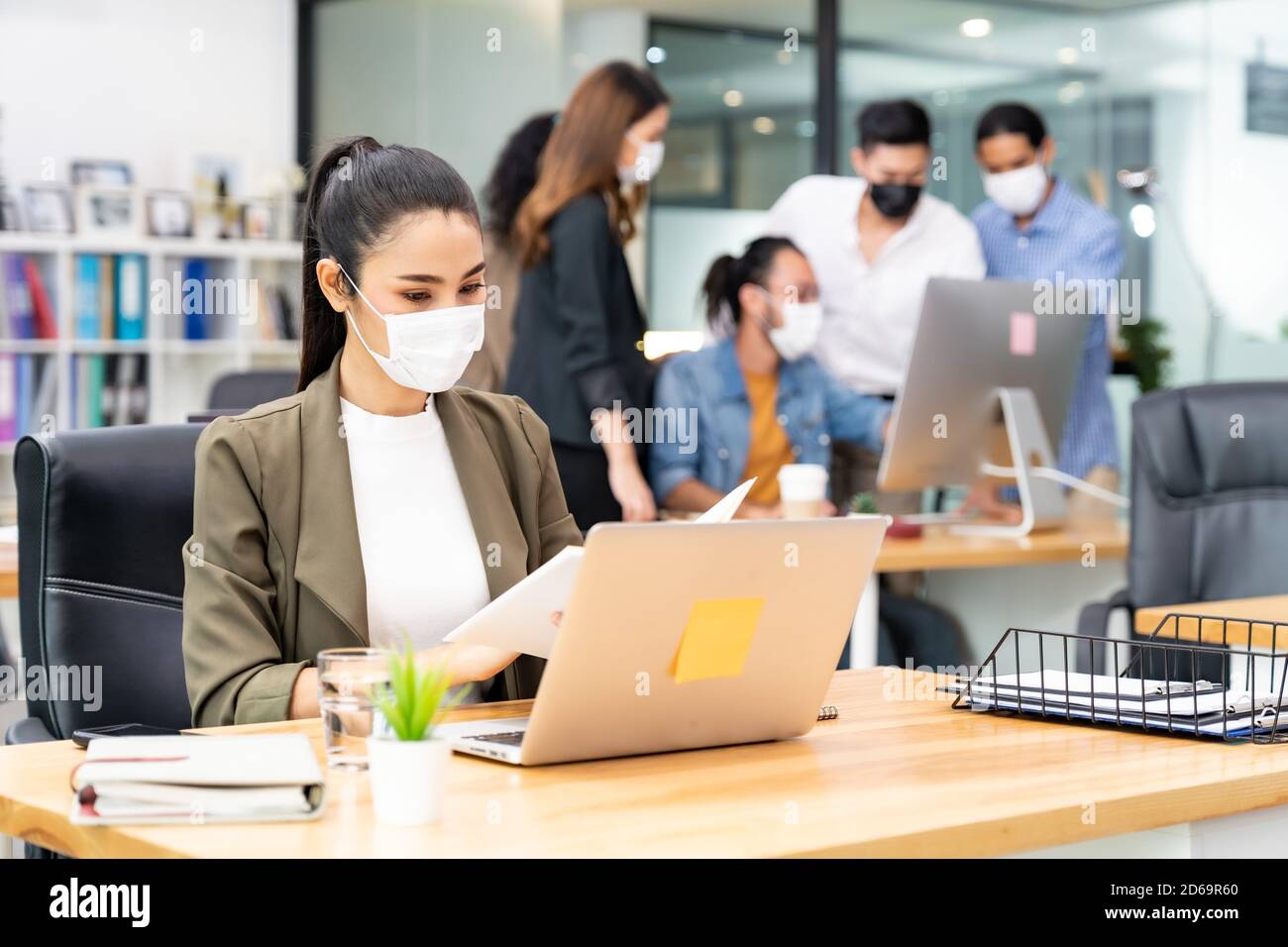 Asian office employee businesswoman wear protective face mask work in ...