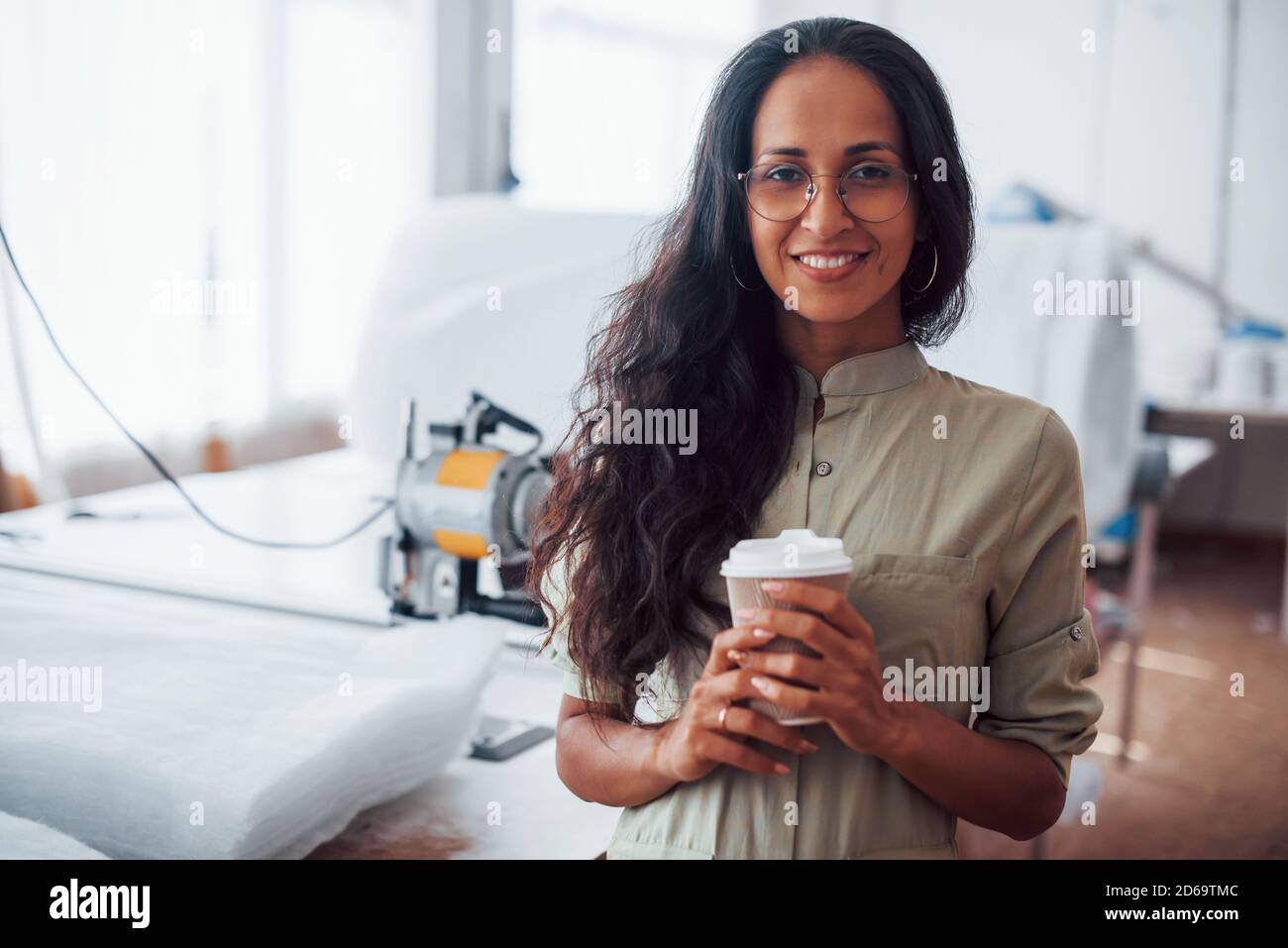 Beautiful female worker with glasses is in the sewing factory Stock ...